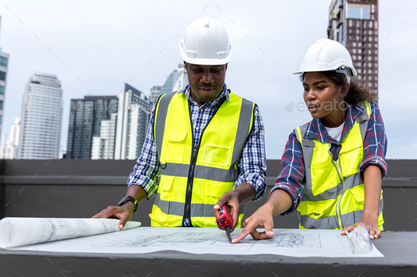 Engineers with draft plan of building on constructing site. Engineer ...