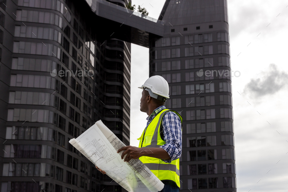 Engineers with draft plan of building on constructing site. Engineer ...