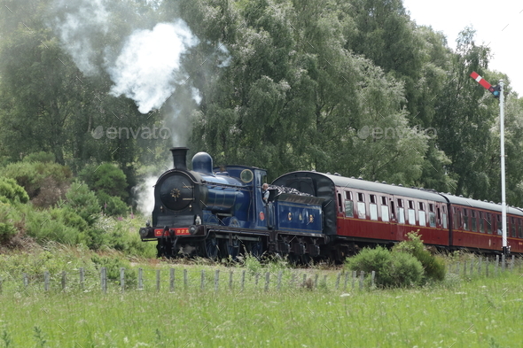 Blue steam locomotive steaming through countryside Stock Photo by ...