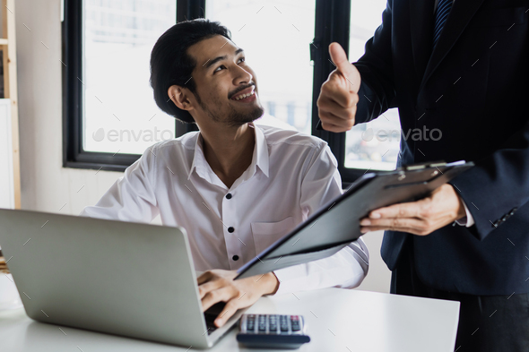 manager show thumb up and admire to worker after seeing profit ...
