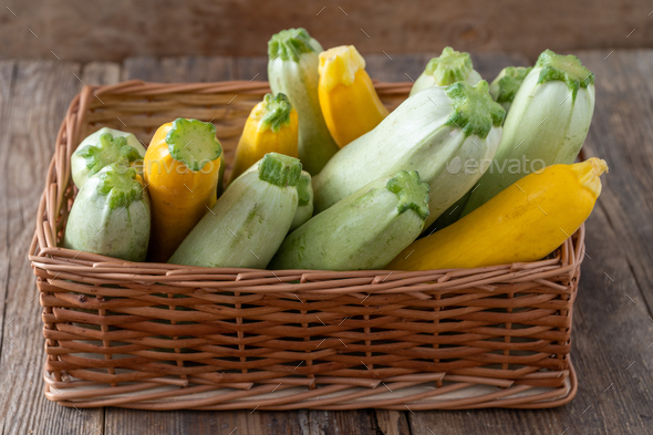 Multi-colored zucchini yellow, green, white, orange on the wooden table ...