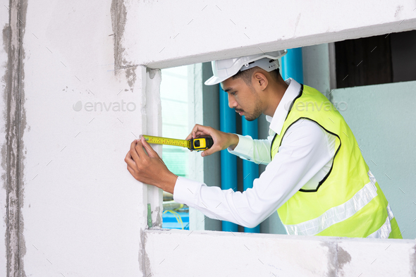 Inspector holding clipboard opening paper and checking building for ...