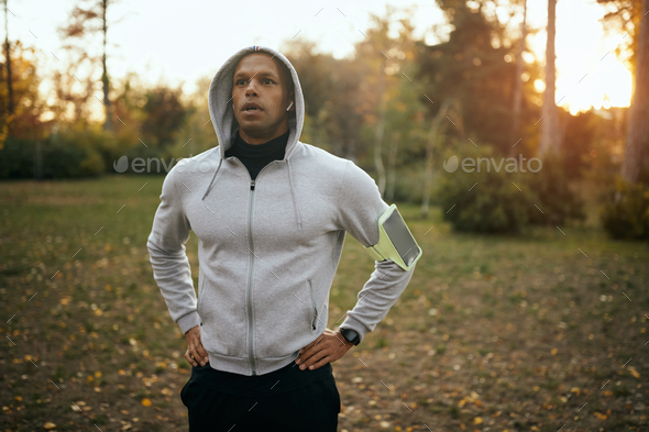 Black athletic man catching his breath after the run in the park at ...