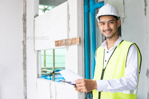Inspector holding clipboard opening paper and checking building for ...