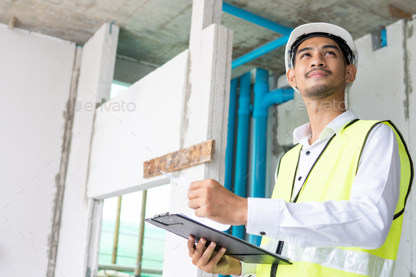 Inspector holding clipboard opening paper and checking building for ...