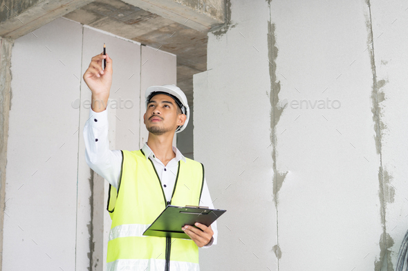 Inspector holding clipboard opening paper and checking building for ...