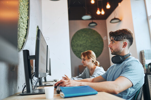 Students learning in computer classroom. Young man preparing for test ...