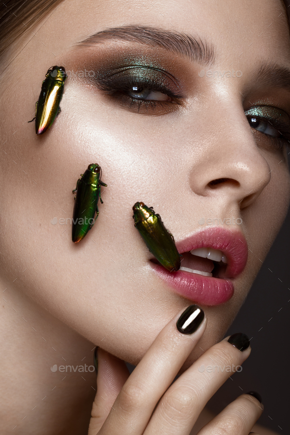 Portrait of beautiful girl with colorful make-up and cockroaches ...