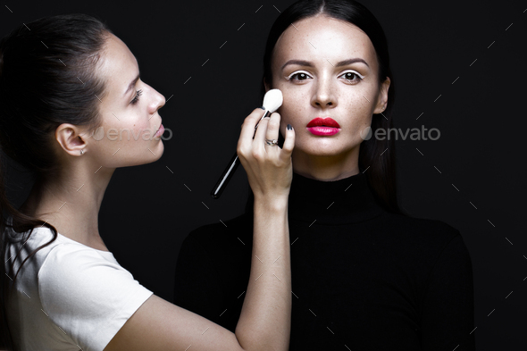 Two beautiful girls on photo shoot to apply face makeup . Beauty ...