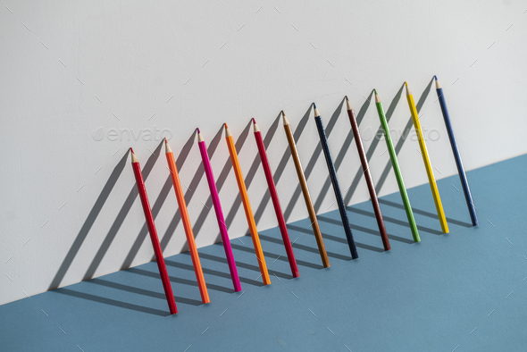 creative colorful crayons layout with the hard shadows on the wall ...