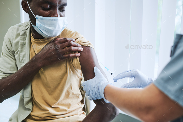 Man looking how nurse making injection Stock Photo by Media_photos