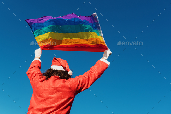 Santa Claus waving a rainbow lgbt pride flag against the wind ...