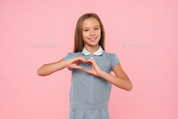 Happy young smiling teenage preteen girl in blue dress showing heart ...
