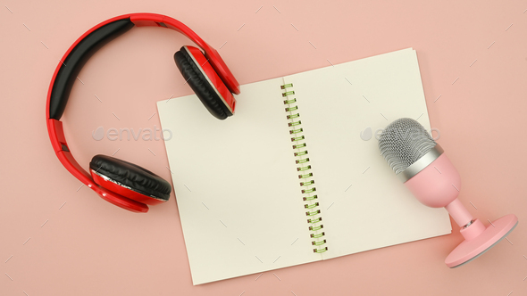 Red wireless headphone and microphone and empty notepad on pink ...