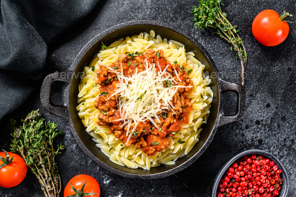Bolognese pasta, risone with ground beef in a plate. Black background ...