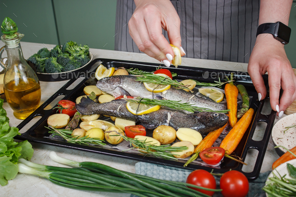 Cooking sea bass fish with aromatic herbs and vegetables Stock Photo by ...
