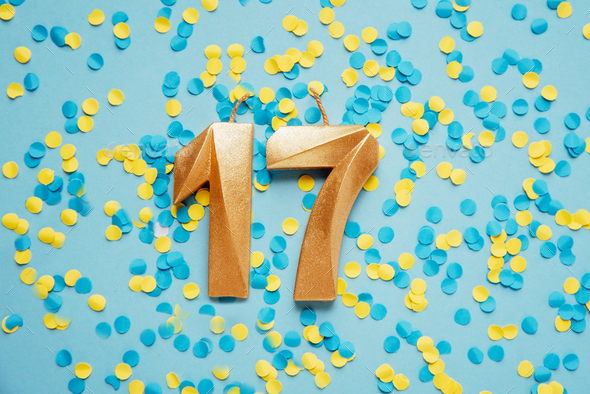Number 17 seventeen golden celebration birthday candle on yellow and ...