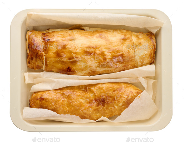 Baked strudel with apple filling in a rectangular pan isolated on white ...