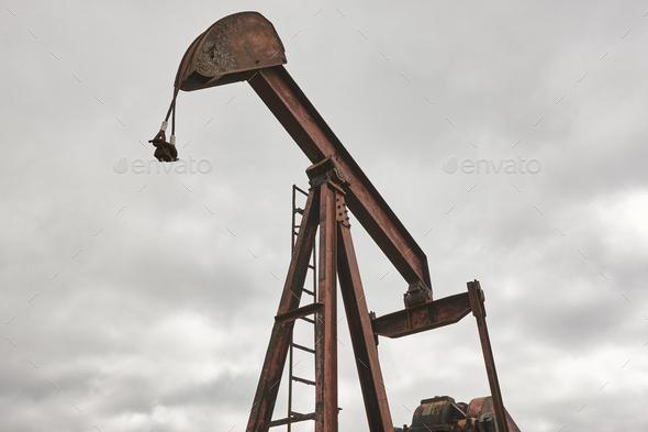 Rusty oil pumping machine. Pump jack. Petroleum extraction. Global ...