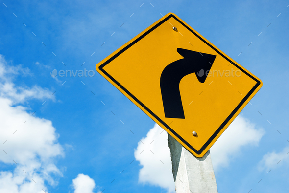 Road sign warning of dangerous left curve on blue sky Stock Photo by osbmxhouse