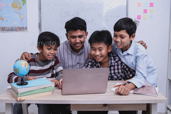 Teacher explain lesson using laptop to students at the classroom Stock ...