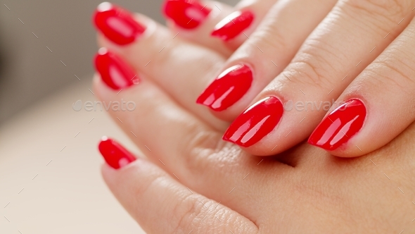 Female hands with fashionable manicure of red color . Woman shows her ...