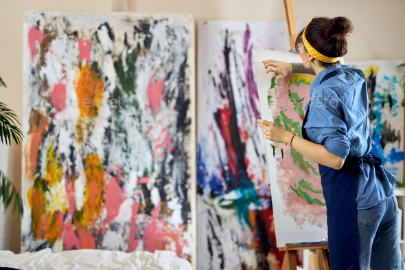 Back view of inspired talented woman, female artist painting at home ...