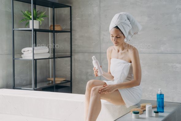 Body care. Female massages hip moisturizing skin with anticellulite ...