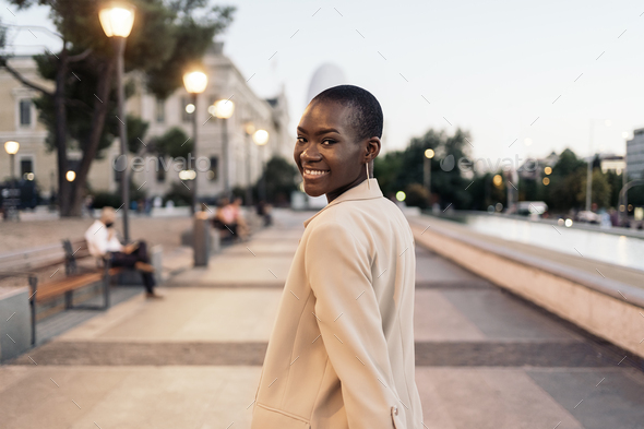 Rear view of a fashionable african american woman turning to look at ...