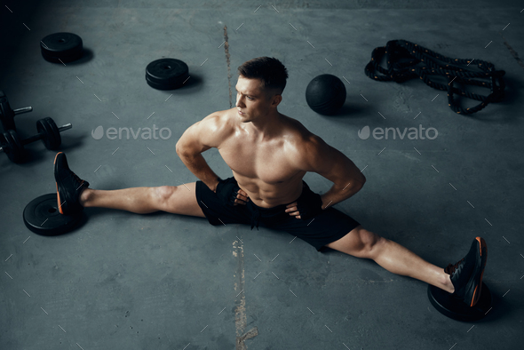 Top view of confident young man doing the splits while exercising in ...