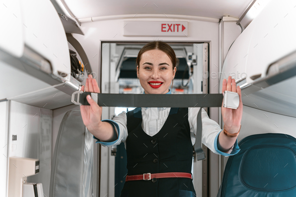 Beautiful flight attendant demonstrates flight safety instruction by ...