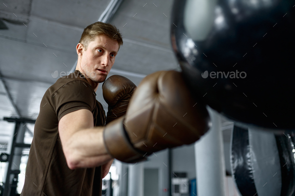 Close up boxer boxing in punching bag with focus on face Stock Photo by ...