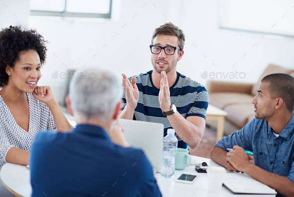 Teamwork in action. Shot of a group of designers at work in an office ...