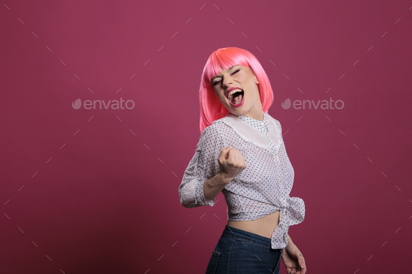 Happy female model celebrating successful triumph Stock Photo by DC_Studio