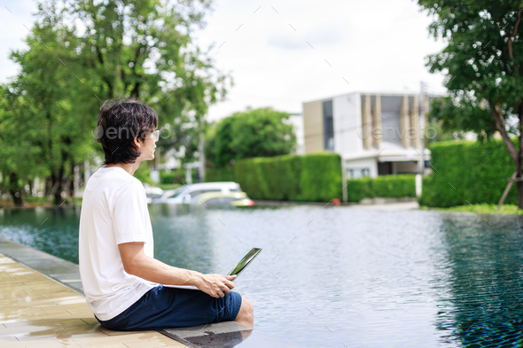 A man remote work during vacation working on his laptop near the ...