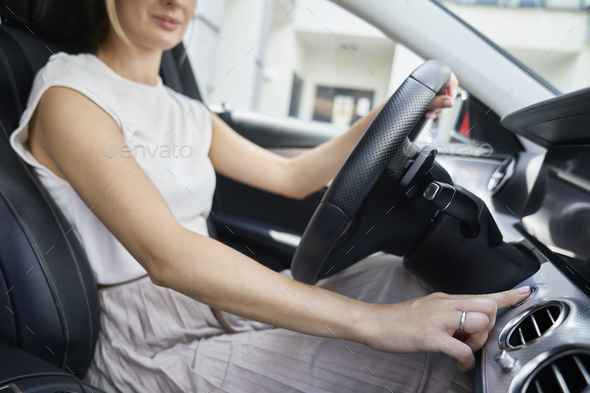 Close up of women's hand starts the car engine Stock Photo by gpointstudio