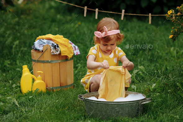 Little cute girl wipes her forehead after finishing washing in nature ...