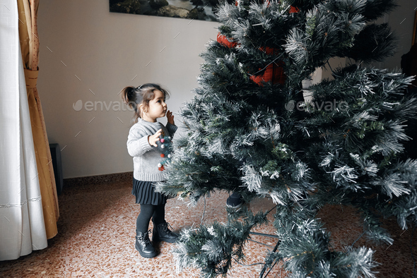A little girl amazed to see the Christmas tree Stock Photo by yosss1