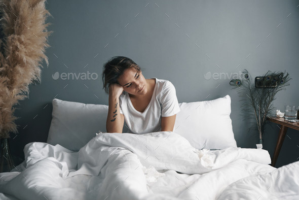 A young woman with a sad face in bed Stock Photo by yosss1 | PhotoDune