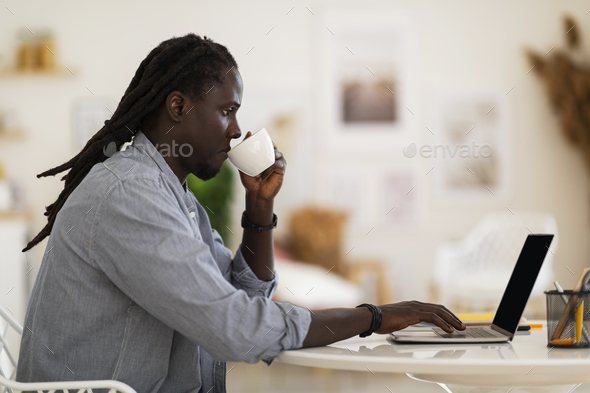 Remote Work. Black Freelancer Guy Working With Laptop And Drinking ...