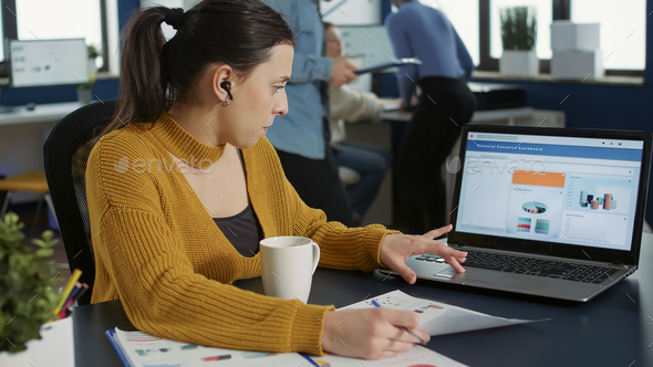 Portrait of startup employee analyzing financial data comparing paper ...