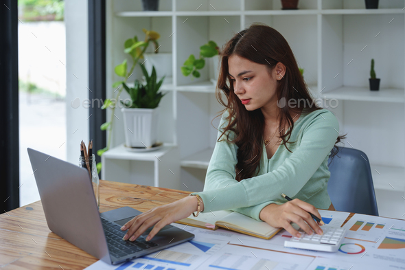 half girl use the computer and calculator to calculate financial ...