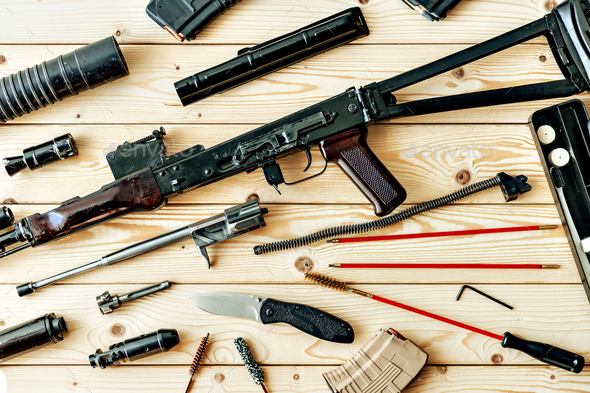 Disassembled rifle with cleaning tools on table of weapons workshop ...