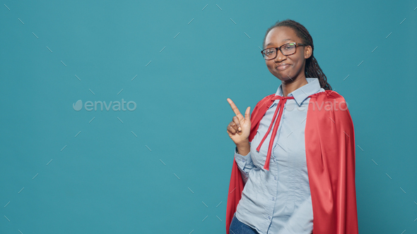 Woman with cape costume pointing left and right Stock Photo by DC_Studio
