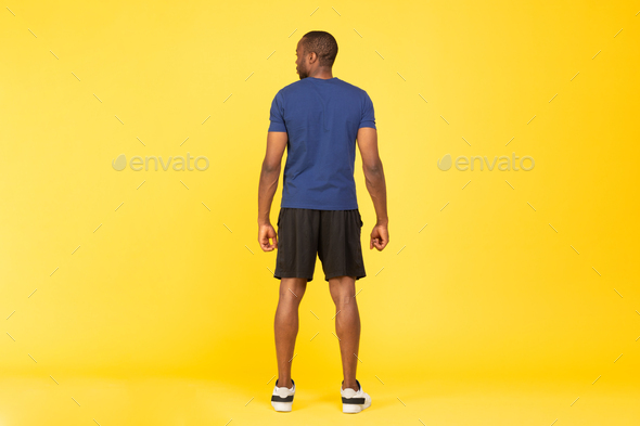Rear View Of Sporty Black Man Standing Over Yellow Background Stock ...
