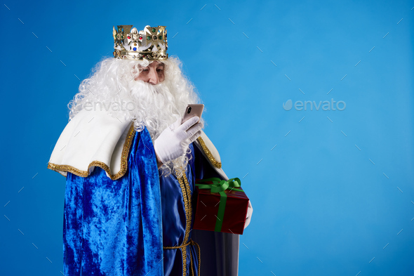 The Magician King using a mobile phone on a blue background Stock Photo ...
