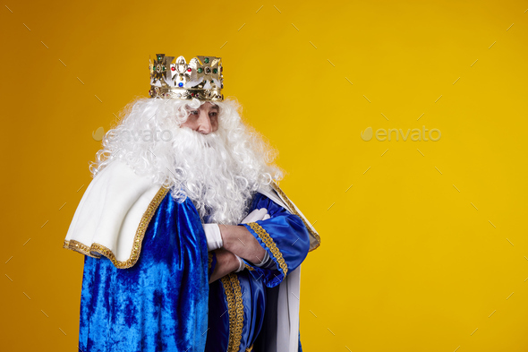 The Magician King with crossed arms on a yellow background Stock Photo ...