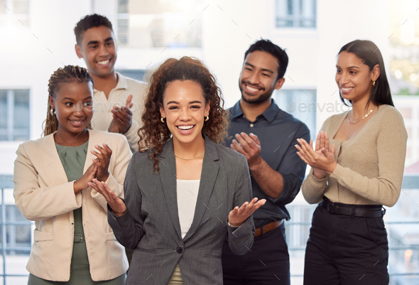 Shot of a group of businesspeople clapping for a colleague at work ...