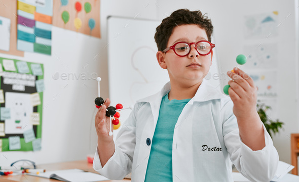 Shot of an adorable young school boy learning about molecules in ...