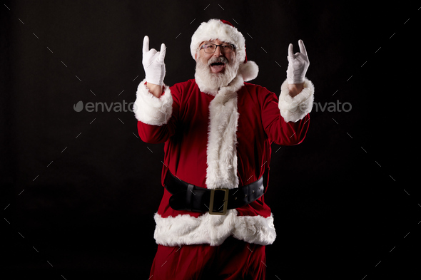 Santa Claus making a rocker gesture on black background Stock Photo by ...